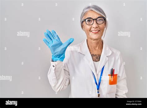 Middle Age Woman With Grey Hair Wearing Scientist Robe Showing And