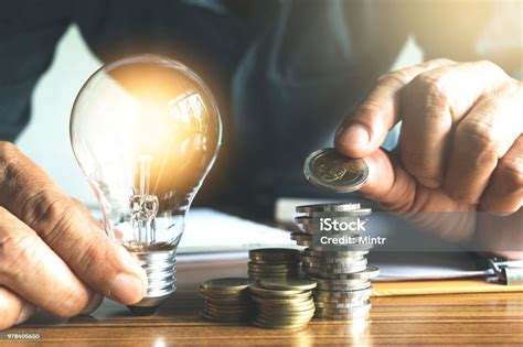 금융 회계 에너지 아이디어 개념에 대 한 사무실에서 책상에 전구 및 동전을 들고 비즈니스 사람 개념에 대한 스톡 사진 및 기타 이미지 Istock