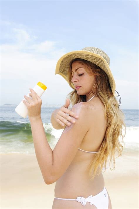 Mujer Que Aplica La Loción Del Bronceado En La Playa Foto de archivo Imagen de playa sombrero