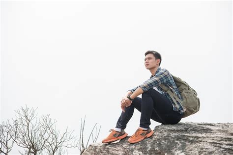 Un Excursionista Masculino Sentado En Un Acantilado Durante El Tiempo