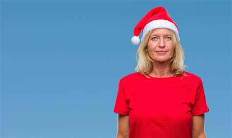 중간 나이 금발 여자 얼굴에 심각한 표정으로 격리 된 배경 위에 크리스마스 모자를 쓰고 간단 하 고 카메라를 보고 자연 겨울에 대한 스톡 사진 및 기타 이미지 Istock