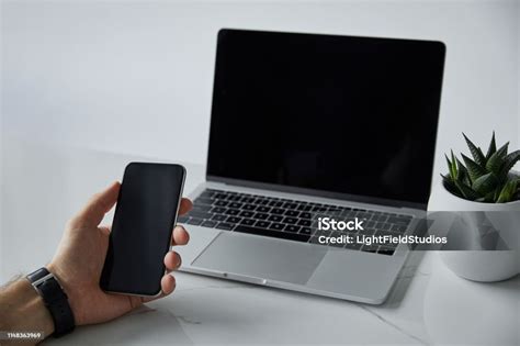 스마트 폰 회색에 빈 화면과 화분이 있는 노트북을 들고 남자의 부분 보기 검은색에 대한 스톡 사진 및 기타 이미지 검은색
