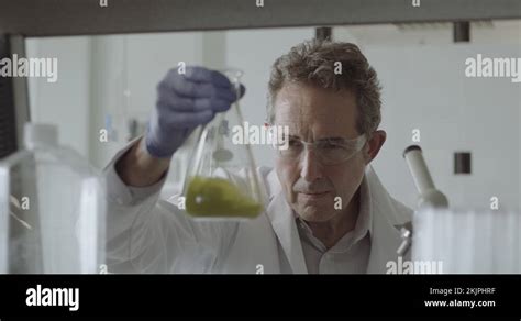 Mature Male Laboratory Scientist Conducts Experiment In Science Lab With Flask Stock Video