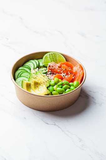 쌀 연어 에다마메 콩 오이 아보카도를 재사용 가능한 골판지 그릇에 넣은 그릇을 찌르세요 하와이 음식 제로 폐기물 개념 포케