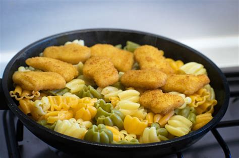 프라이팬에 치킨 너겟을 곁들인 파스타 프라이드 치킨 너겟 맛있고 바삭바삭한 치킨 너겟 어린이 메뉴 0명에 대한 스톡 사진 및