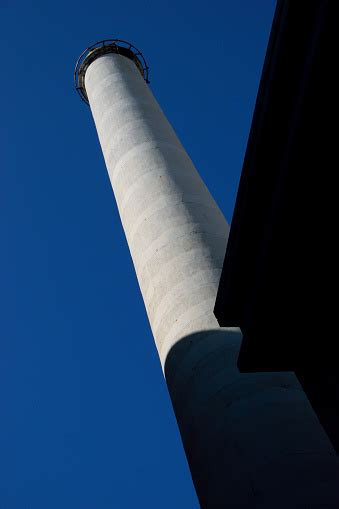 단일 요소입니다 짙은 파란색의 밝은 푸른 열대 여름 하늘을 배경으로 뚜렷하게 서 있는 오래된 직물 공장의 굴뚝에 닿는 하늘은 사용되지 않습니다 0명에 대한 스톡 사진 및