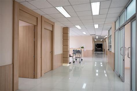 리셉션에서 다양한 방과 트롤리 환자 서비스를 제공하는 빈 병원 복도 내부 프리미엄 사진