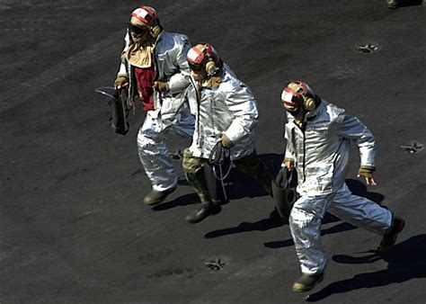 A Crash And Salvage Team Move Along The Flight Deck Aboard The Uss