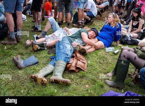 A Man Takes A Nap On His Partner S Lap Middle Aged Festival Goers At