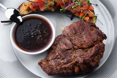 Grilled Steak With Sauce And Vegetables On A White Plate Stock Image
