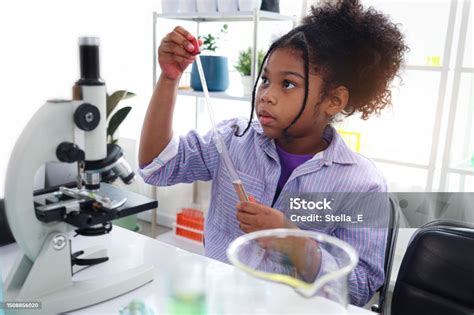초등학교 아프리카 곱슬머리 소녀는 실험실에서 화학 과학 실험을 하고 귀여운 과학자 아이는 화학 시험관을 들고 아이는 실험실 장비를 사용하여 생물학적 제제 교실에서 화학을