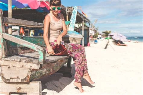 Premium Photo Girl On The Beach Holding A Clutch Made Of Exotic Python Skin