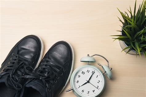 냄비와 검은 캐주얼 가죽 신발에 녹색 나무와 나무 테이블 배경에 녹색 파스텔 컬러로 빈티지 알람 시계 0명에 대한 스톡 사진 및