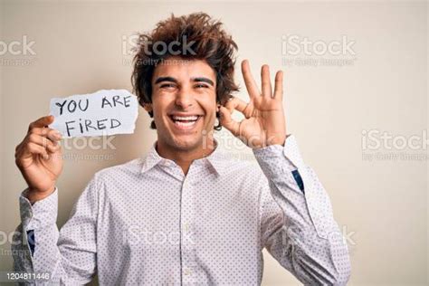 손가락으로 확인 기호를하고 고립 된 흰색 배경 위에 서 메시지와 함께 종이를 들고 젊은 잘 생긴 남자 우수한 기호 개념에 대한