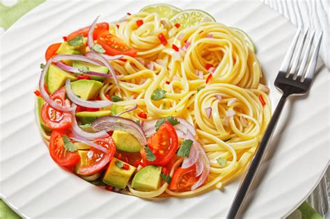 아보카도 토마토 라임과 함께 다진 칠리와 붉은 양파를 나무 테이블에 흰 접시에 뿌린 파스타 0명에 대한 스톡 사진 및 기타