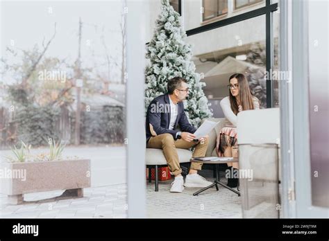 Small Team Of Business Professionals Collaborating In An Office Analyzing Statistics And