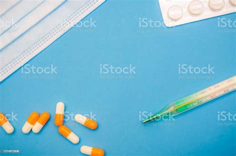 의료 마스크 오렌지와 흰색 캡슐 온도계 파란색 배경에 알약과 복사 장소가있는 장소 응급 처치 질병 중 관리 배경 개념에 대한