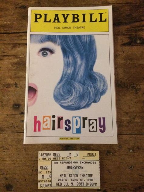 An Advertisement For Hairspray On A Wooden Floor Next To A Pair Of Scissors