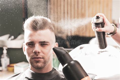 Girl Hairdresser Sprays Spray And Dries Hair With A Hairdryer To A