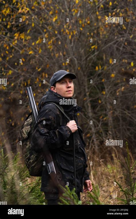 Hunter With A Gun And A Backpack In The Forest High Quality Photo