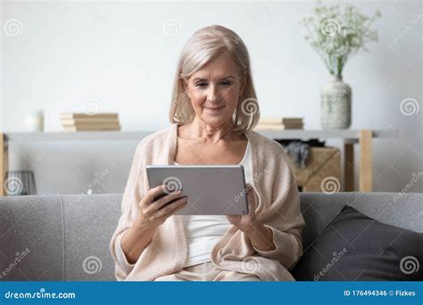Portrait De La Femme âgée Moyenne Agréable à Laide Du Comprimé Photo