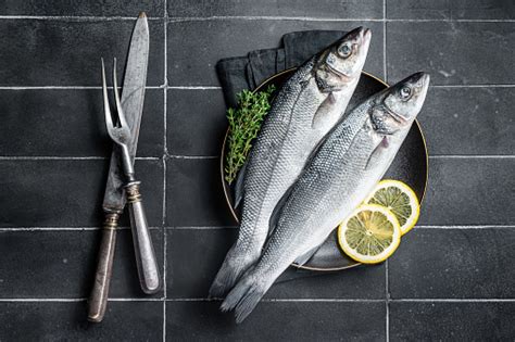 Ikan Bass Laut Mentah Segar Dengan Lemon Dan Thyme Latar Belakang Hitam