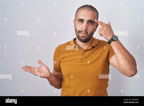 Hispanic Man With Beard Standing Over White Background Confused And