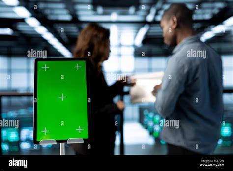green screen mockup tablet in front of technicians in blurry background