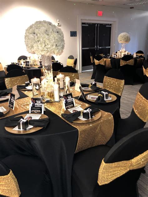 A Banquet Room Set Up With Black And Gold Linens
