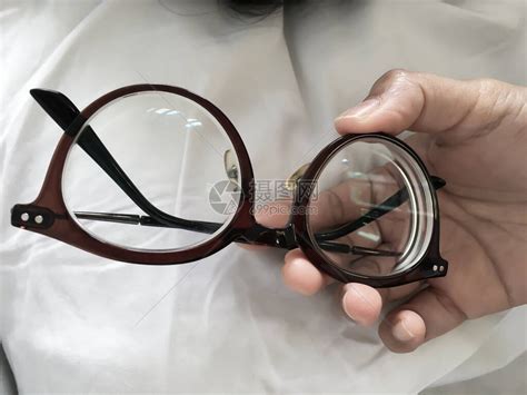 女人的手拿着近视或近视眼镜在白色枕头白色床背景特写和微距拍摄选择聚高清图片下载 正版图片506428790 摄图网