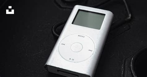 An Ipod Sitting On Top Of A Black Table Photo Free Electronics Image