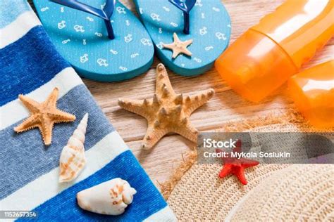 플립 플롭 밀 짚 모자 불가사리 선크림 병 바디 로션 나무 배경 평면도에 스프레이 편평한 누워 여름 바닷가 바다 부속품 배경 Vaation 개념 개념에 대한 스톡 사진 및