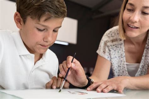 Mère Aidant Son Fils à Finir De Peindre Photo Gratuite