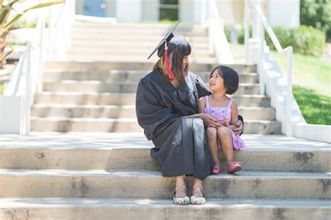 그녀의 졸업식 모자와 가운을 입고 중 년 어머니가 딸과 함께 계단에 앉 았다 아이에 대한 스톡 사진 및 기타 이미지 아이 어머니 캠퍼스 Istock