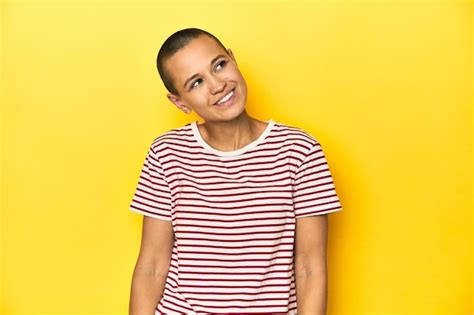 Premium Photo Shaved Head Woman In Red Striped Tee Yellow Backdrop