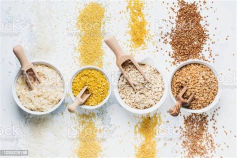 시리얼 조각 쌀 기장 메 밀 오트밀의 다양 한 밝은 나무 배경에 흰색 세라믹 그릇 Superfood 최고의 볼 수 있습니다 가정