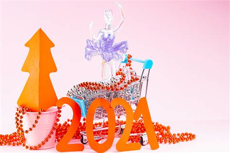 빨간 크리스마스 트리와 장바구니에 2021 년 비문 분홍색 배경에 쇼핑 카트에 크리스마스 트리 장식 휴일 컨셉 12월에 대한