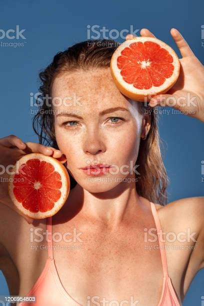 여름 자유형 주근깨와 젖은 머리를 가진 젊은 여자는 자몽 반쪽 펜션과 함께 파란색 포즈에 고립 된 서 감귤류 과일에 대한 스톡 사진 및 기타 이미지 Istock