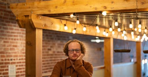 개인 검은 안경 고요한 곱슬머리 구성 남자 대학 디자이너 따뜻한 라이프스타일 러스틱 목조 구조 미국 미소 반사 벽돌 벽 북미 사교적인 사색