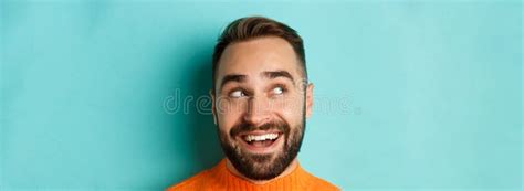 Headshot Of Handsome Caucasian Man Looking At Upper Left Corner Logo And Smiling Pleased