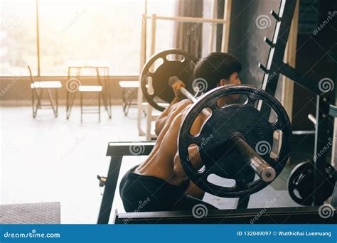 Asian Man Performing Barbell Squats At The Indoor Gym Stock Image