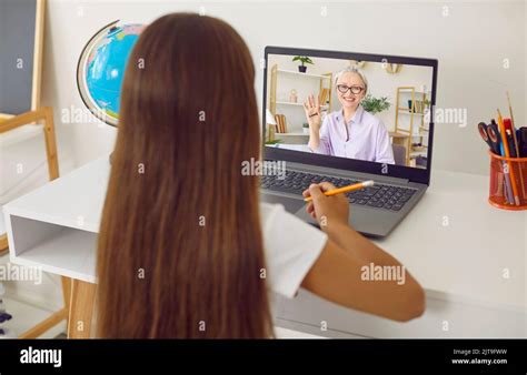 School Girl Sitting In Front Of Laptop Computer And Having Online Class