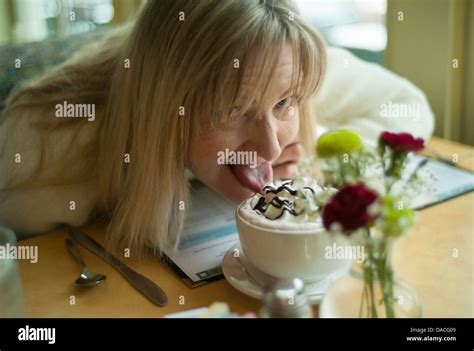 Femme De Lécher La Crème Fouettée Sur Le Dessus Dune Tasse Photo Stock