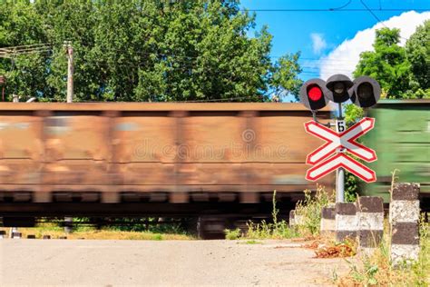 Red Signal Of Semaphore And Stop Sign In Front Of Railroad Crossing With Train Passing Stock
