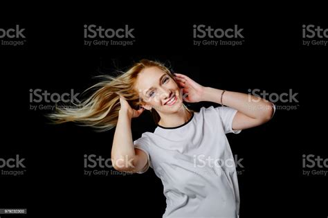 긴 팔 딱 머리를 가진 아름 다운 금발 소녀입니다 검은 배경에 흰색 T셔츠 치 어 리더에 스포티 한가 냘 픈 여자의 초상화 T