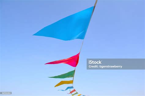 푸른 하늘에 대 한 밧줄에 매달려 삼각형 플래그입니다 필터링 되지 않은 자연 스러운 조명 다중 축 하 파티에 삼각 깃발 색깔 0
