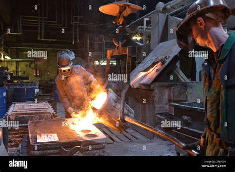 Workers In A Foundry Casting A Metal Workpiece Safety At Work And