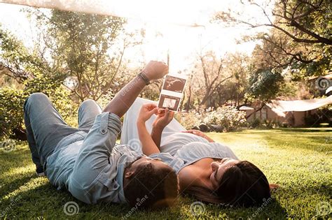 Pregnant Latina Woman And African Couple Laying In A Green And Sunlit