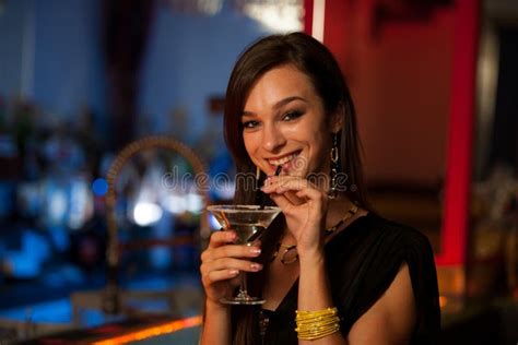 Девушка выпивает коктеиль Colada Pina в ночном клубе Стоковое
