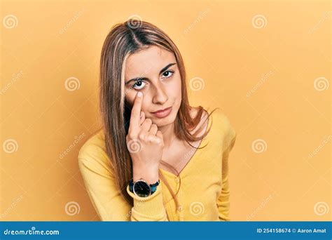 Beautiful Hispanic Woman Wearing Casual Yellow Sweater Pointing To The